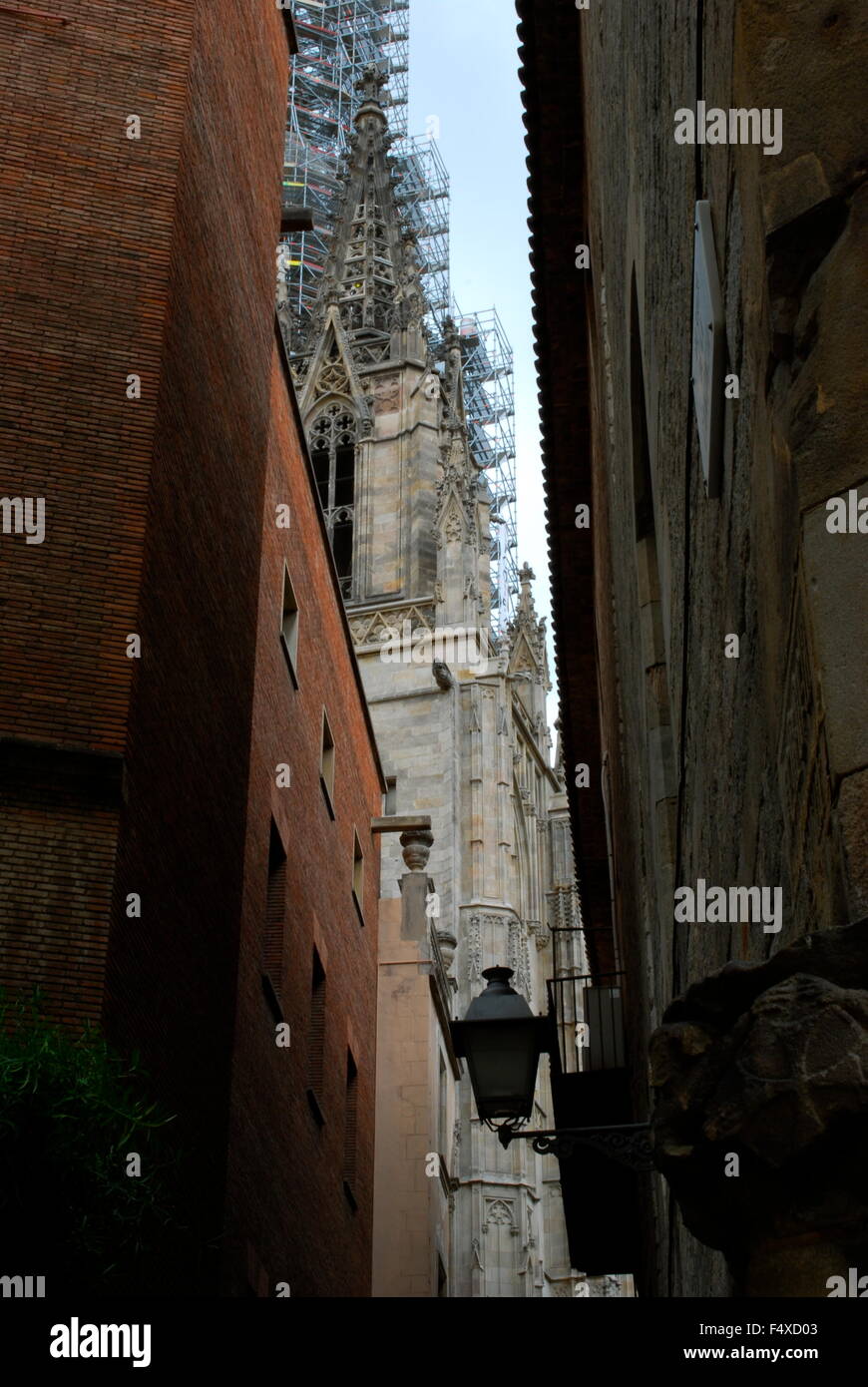 Church tower with scaffolding viewed from a narrow street between two ...
