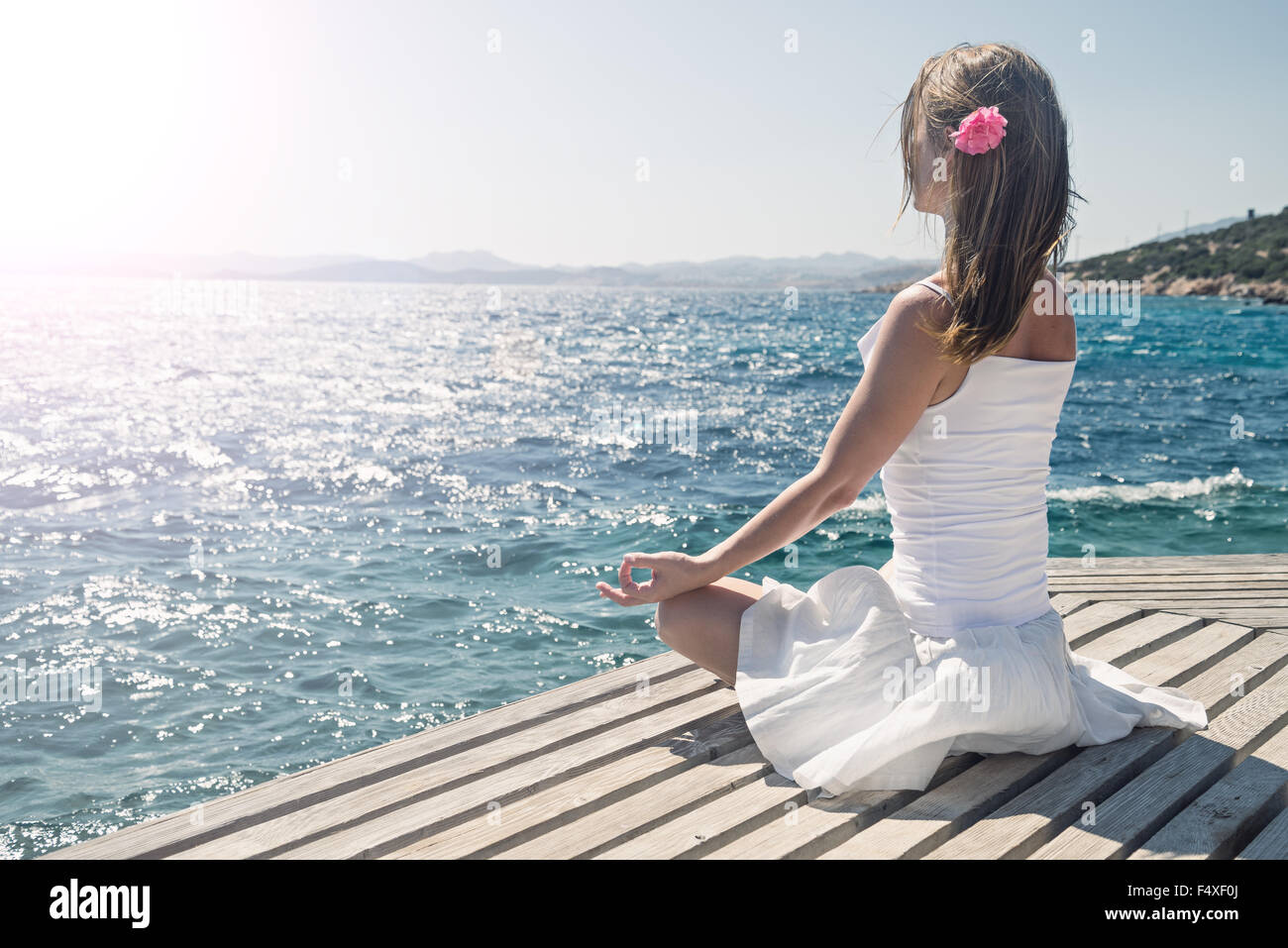 Woman meditating at the sea Stock Photo - Alamy