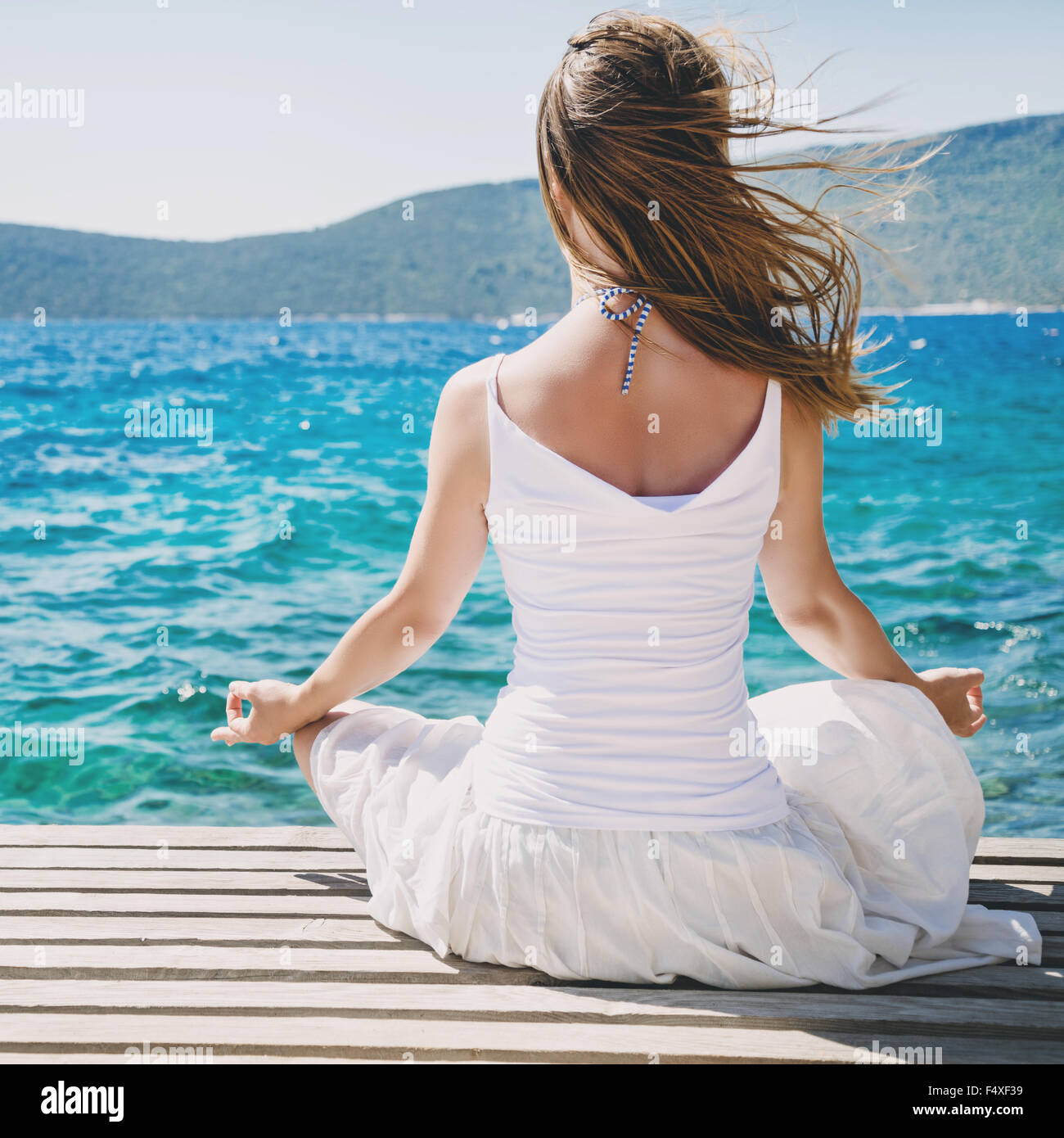 Woman meditating at the sea Stock Photo - Alamy