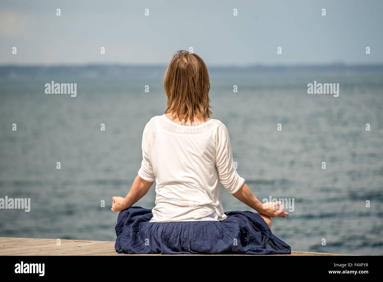 Woman meditating at the sea Stock Photo - Alamy