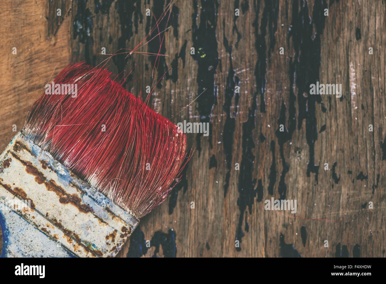 Old used paintbrush on rustic wooden board, retro toned with blank copy ...