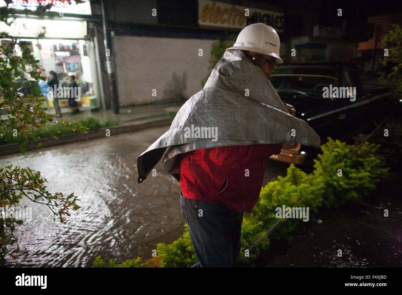 Ameca, Mexico. 23rd Oct, 2015. A man protects himself from the rain ...