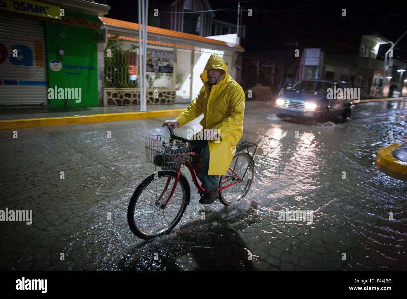 Ameca, Mexico. 23rd Oct, 2015. A man rides his bicycle in the rain ...