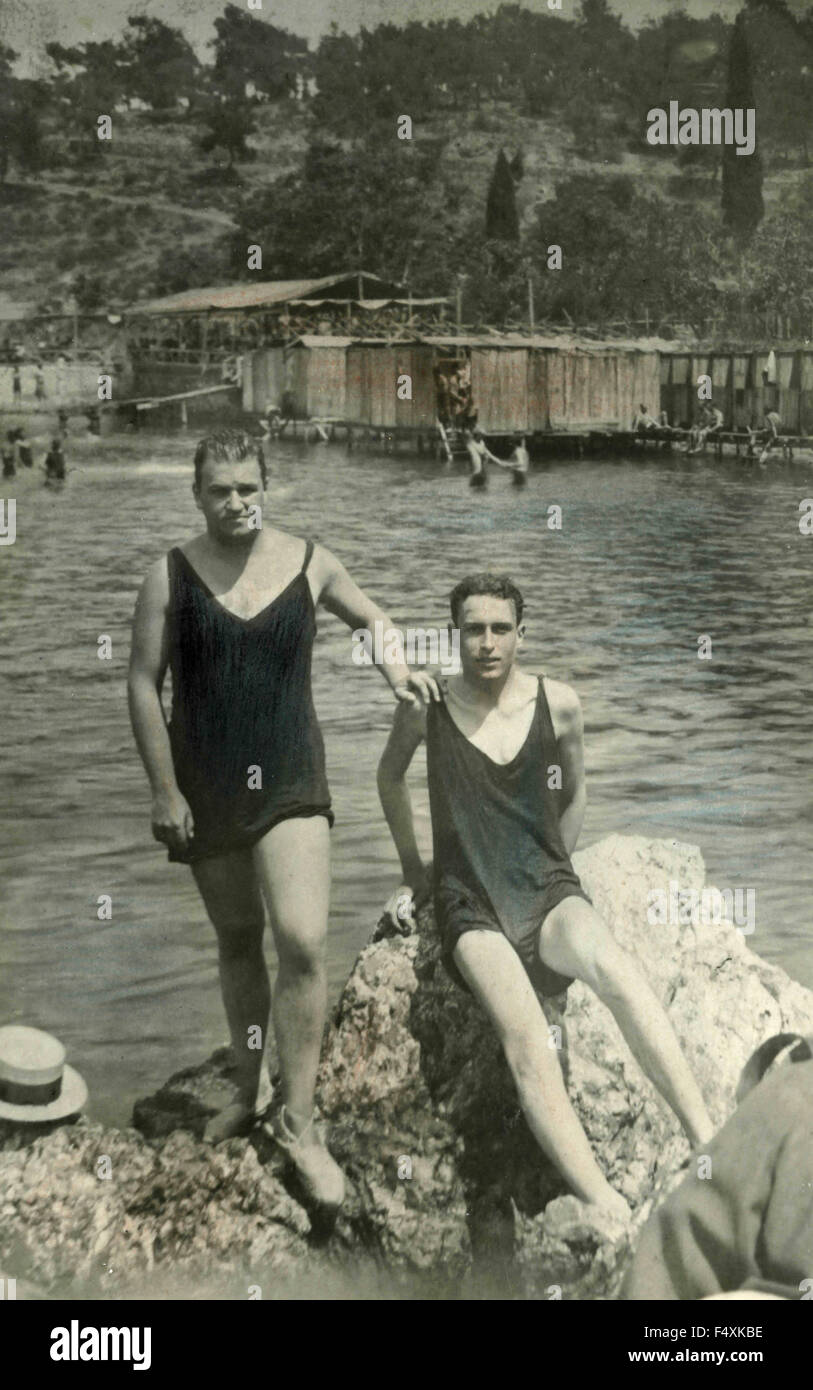 Two friends on the rocks with one-piece black swimsuits, Italy Stock ...