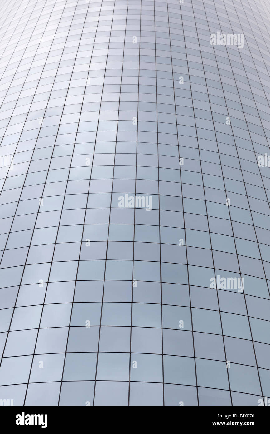 curved facade of skyscraper with reflections of clouds and sky in new ...