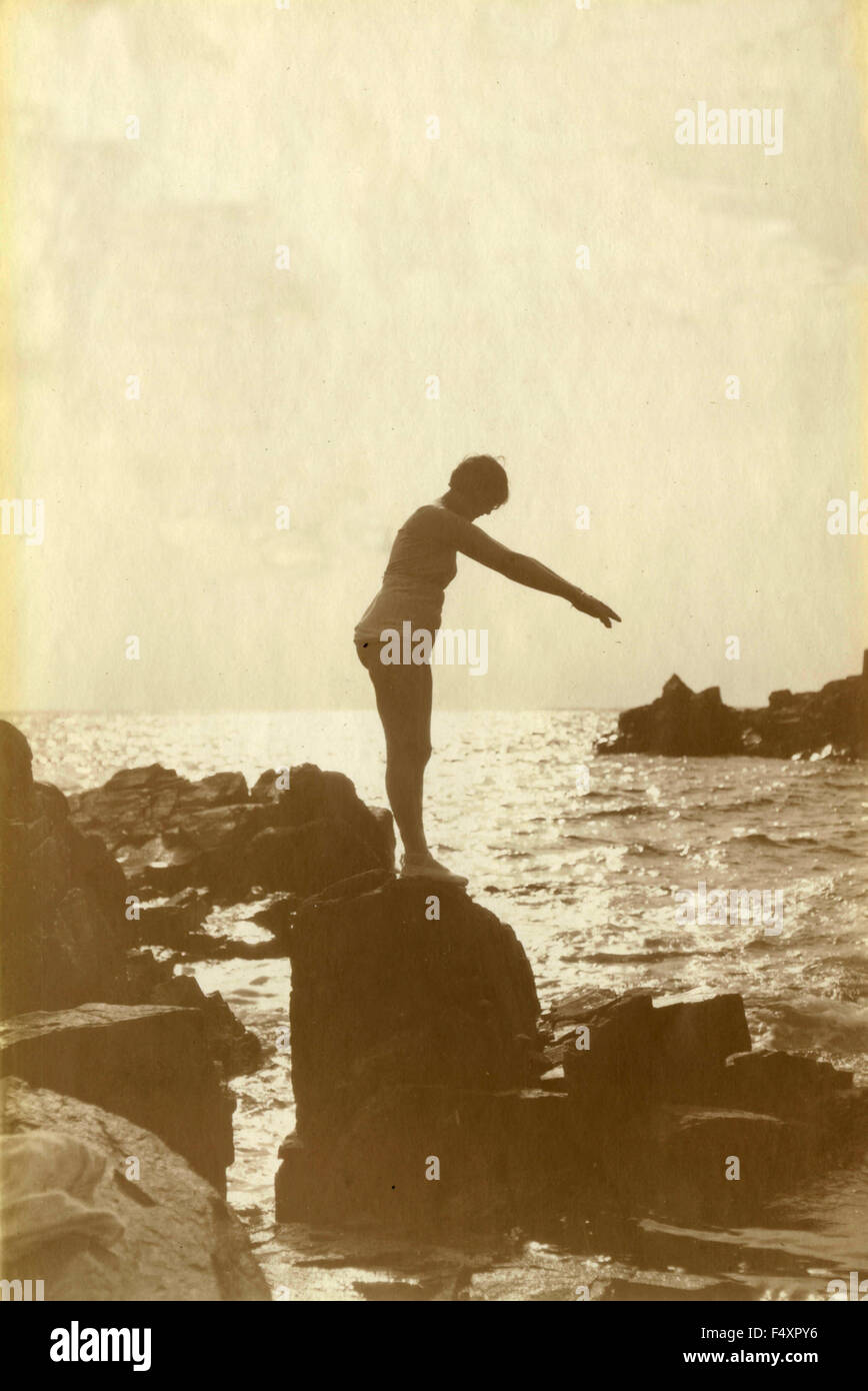 A woman by the sea on the rocks in plastic pose, Denmark Stock Photo ...