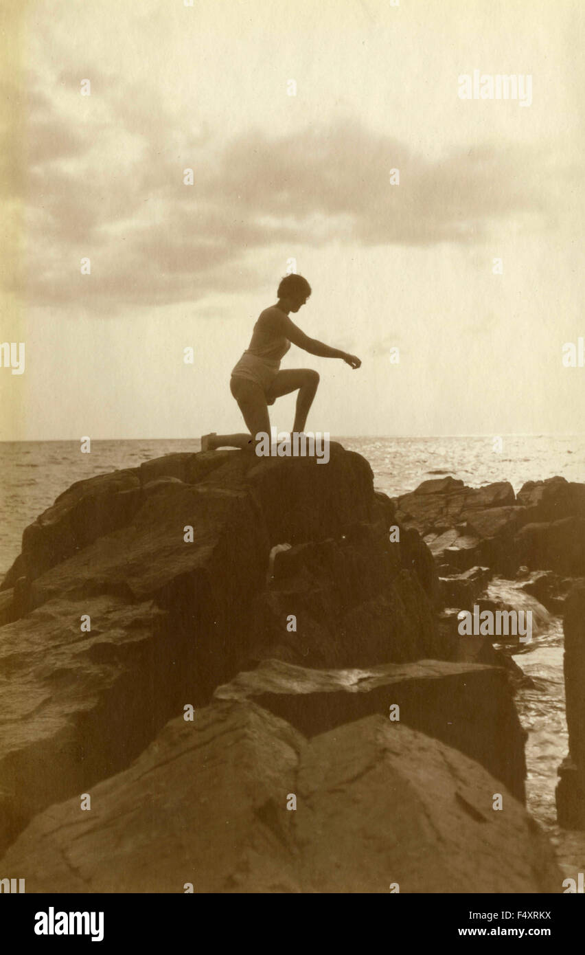 A woman by the sea on the rocks in plastic pose, Denmark Stock Photo ...
