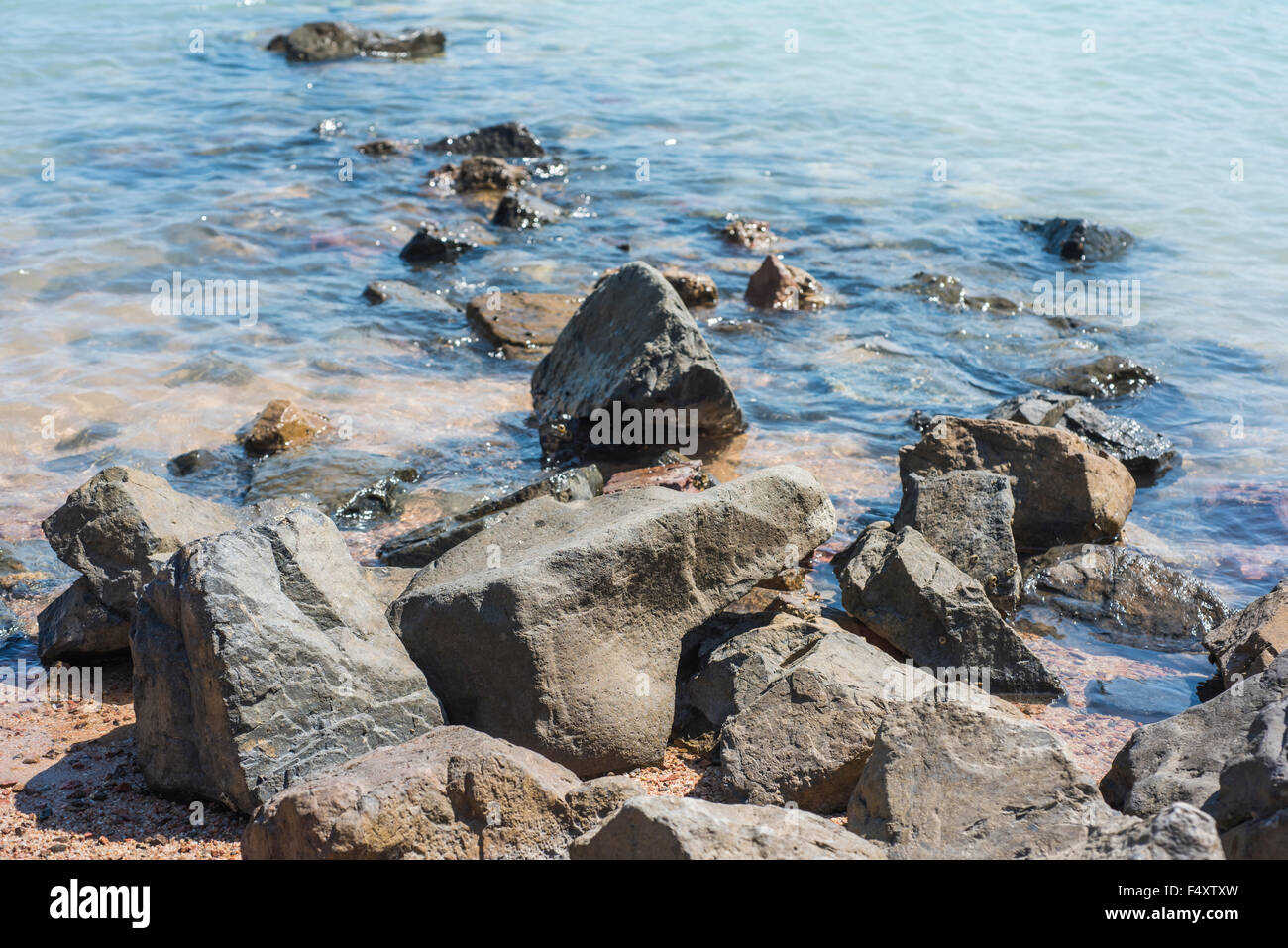 Closeup detail of rocks on a tropical beach shore line Stock Photo - Alamy