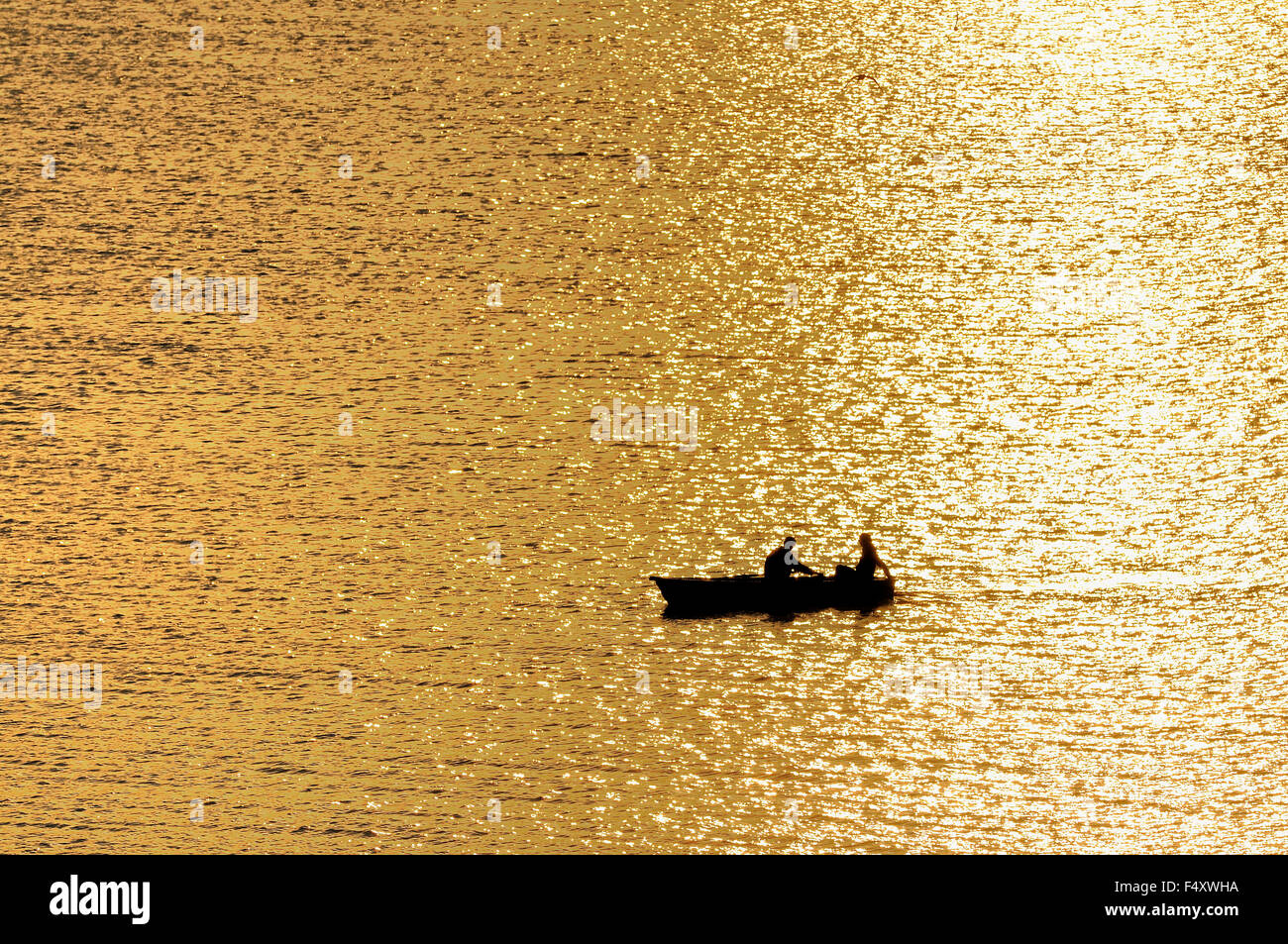 Rowing boat with two people, at sunset, Achterwasser, Usedom Island ...