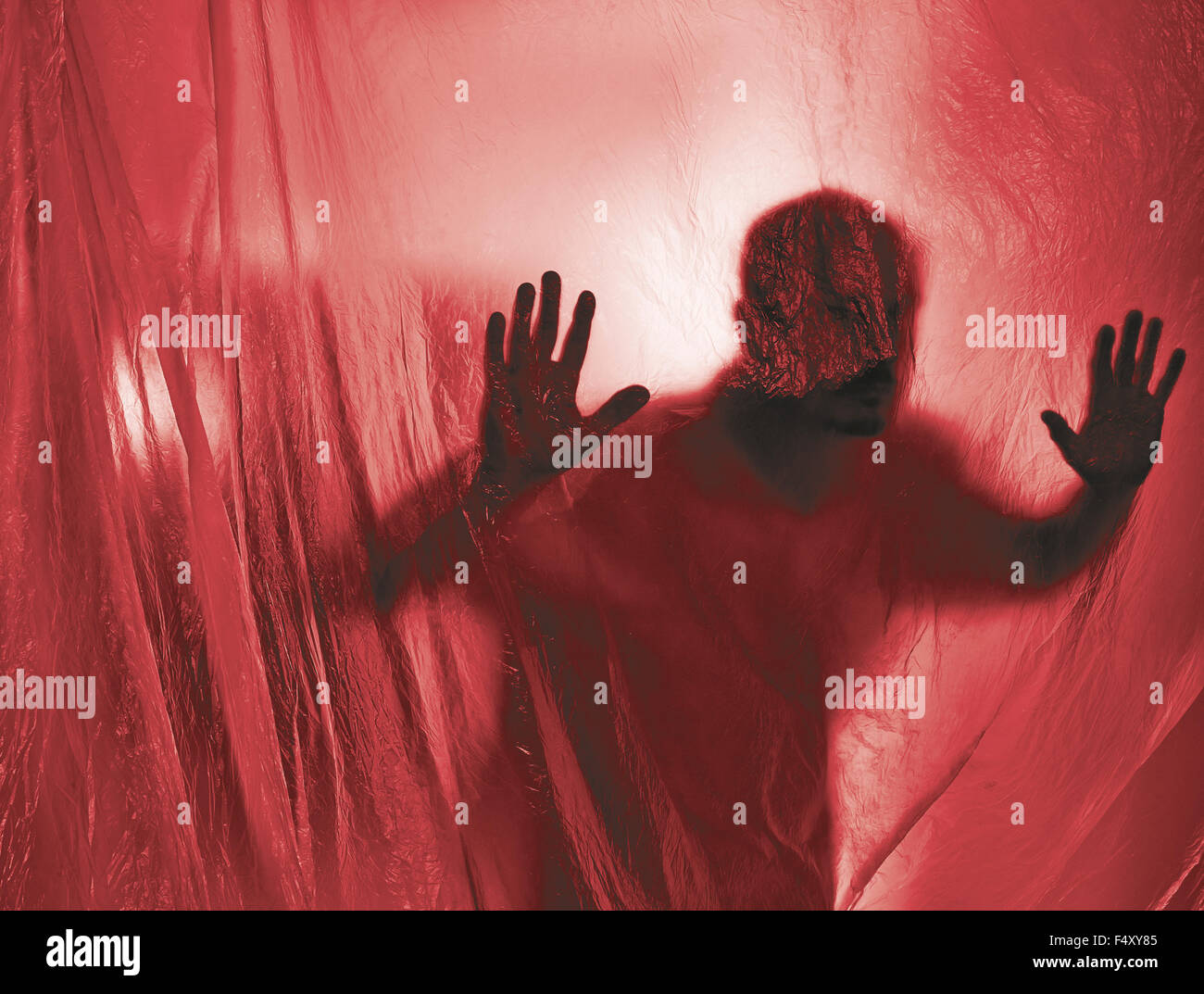 Silhouette of a man behind a red transparent plastic Stock Photo - Alamy