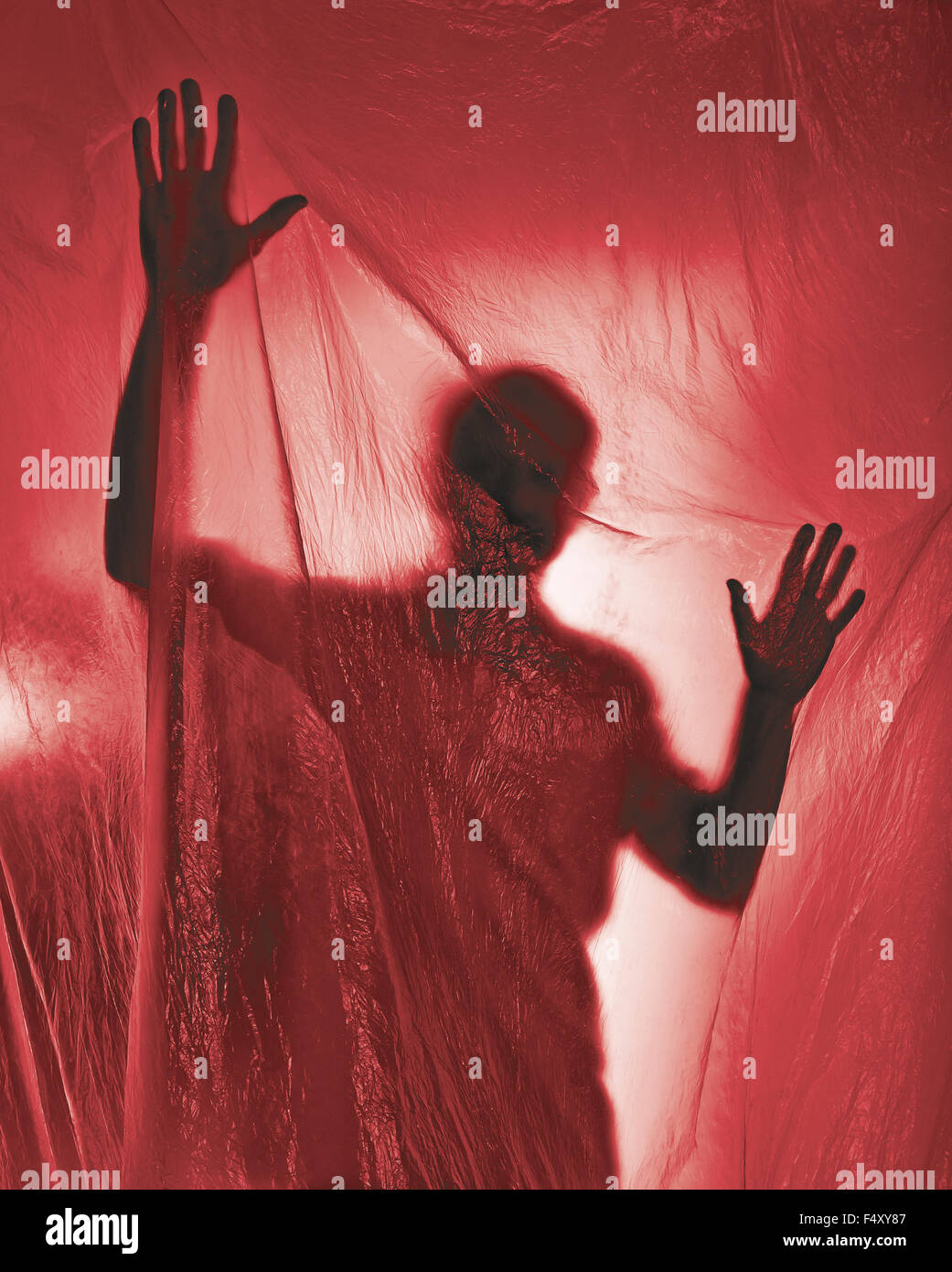 Silhouette of a man behind a red transparent plastic Stock Photo - Alamy