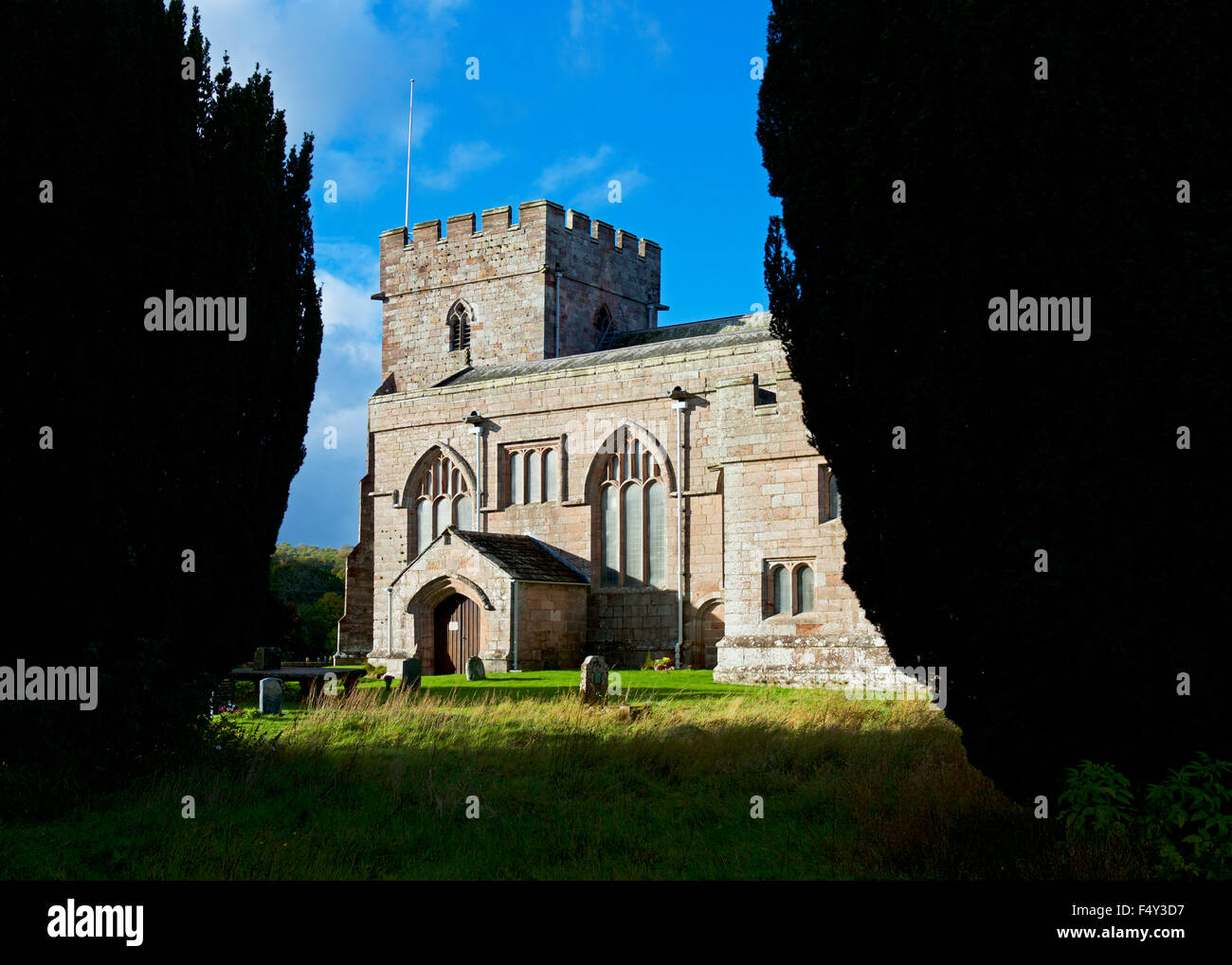St Andrew's Church, Greystoke, Cumbria, England UK, framed by yew trees ...