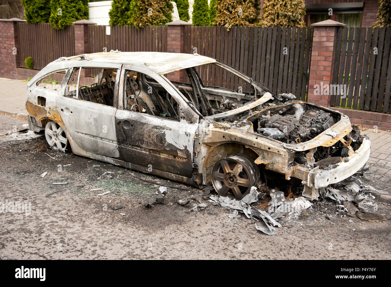 Burnt car in arson fire, white car wreck at the pavement in Poland ...