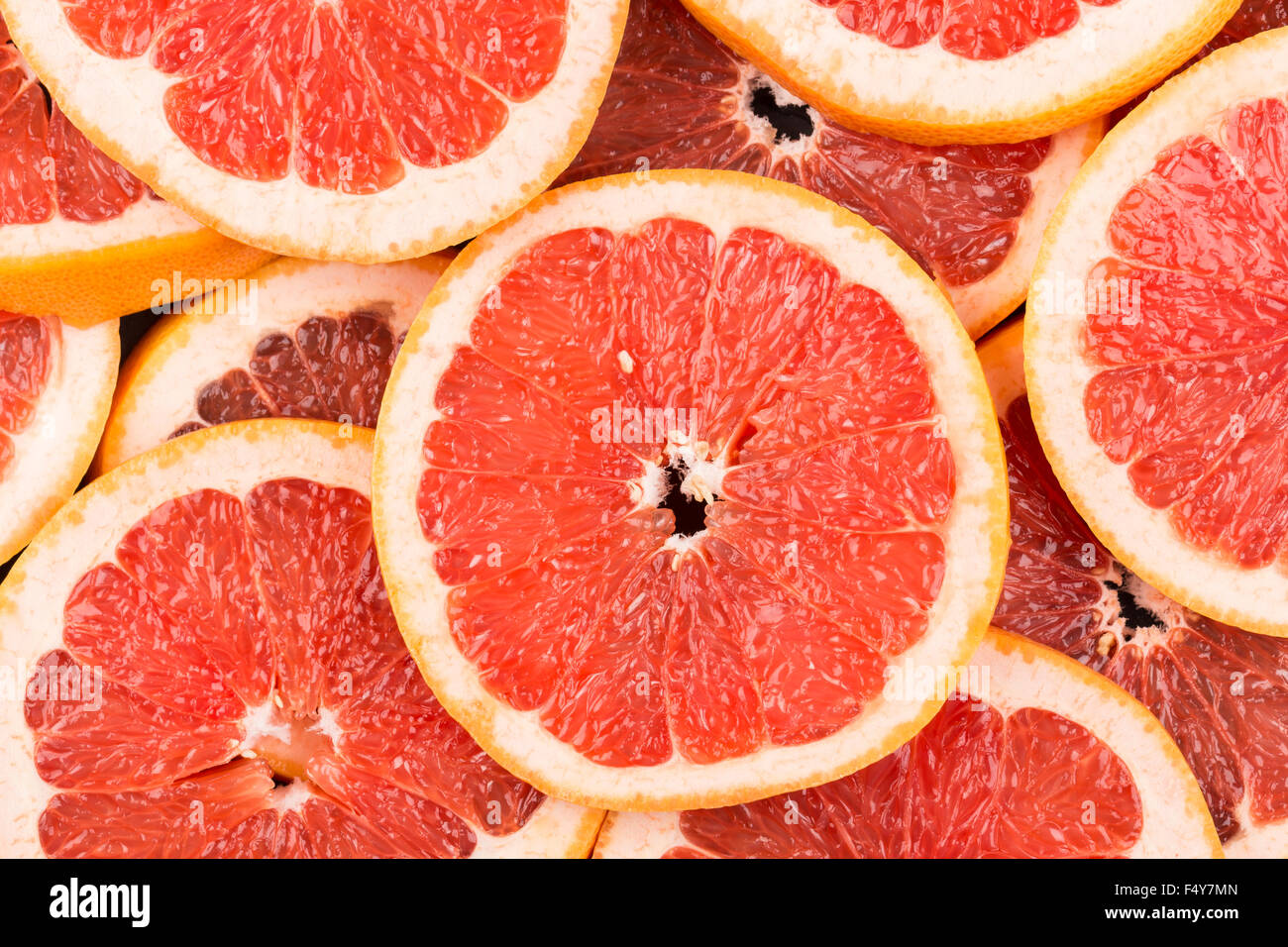 Abstract red background with citrus-fruit of grapefruit slices. Close ...