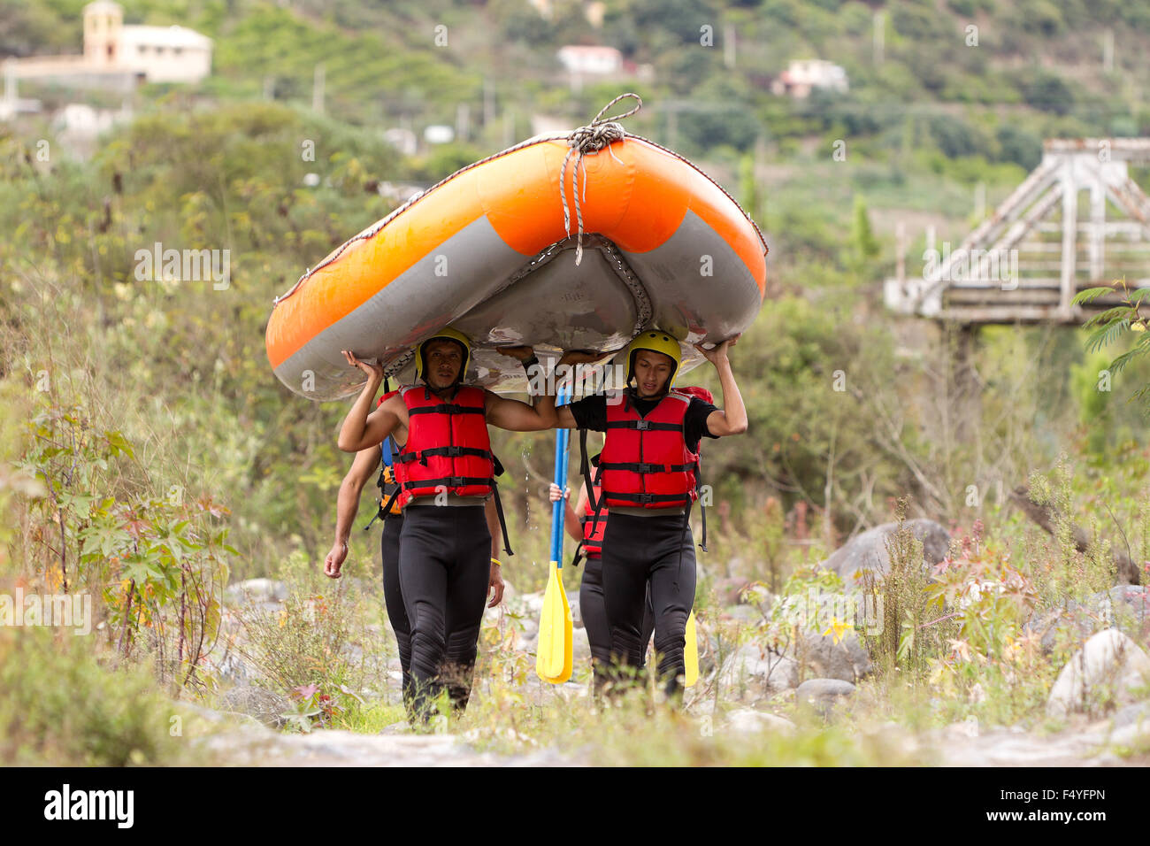 Group Of Young Adult Carrying A Rafting Boat Stock Photo - Alamy