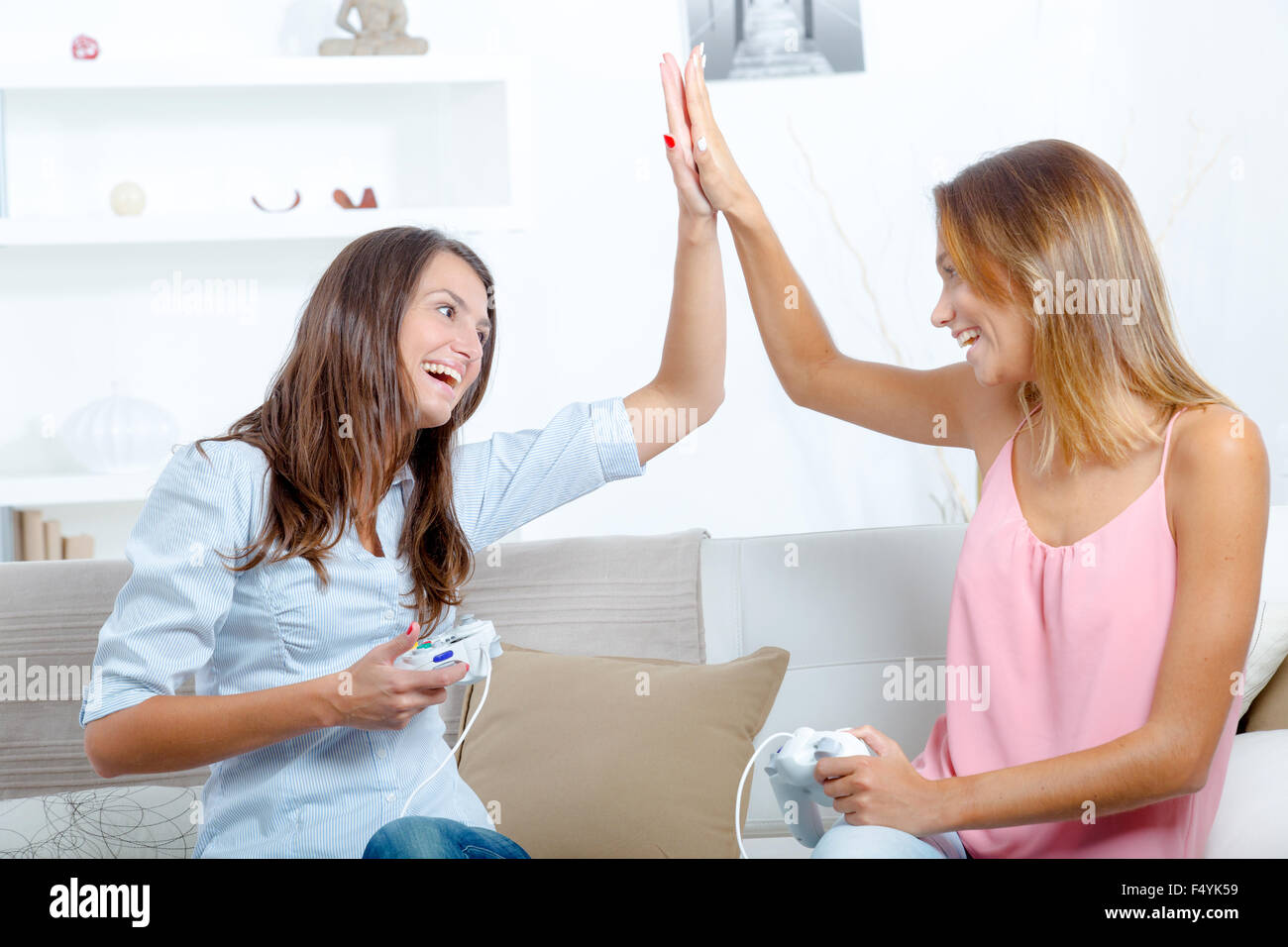 Two female friends playing video games Stock Photo - Alamy