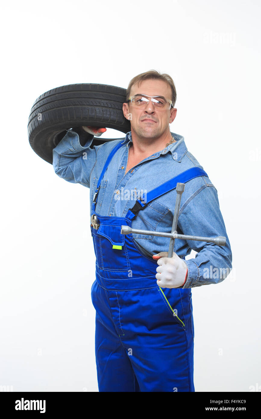 adult male mechanic with a wrench and tire Stock Photo - Alamy