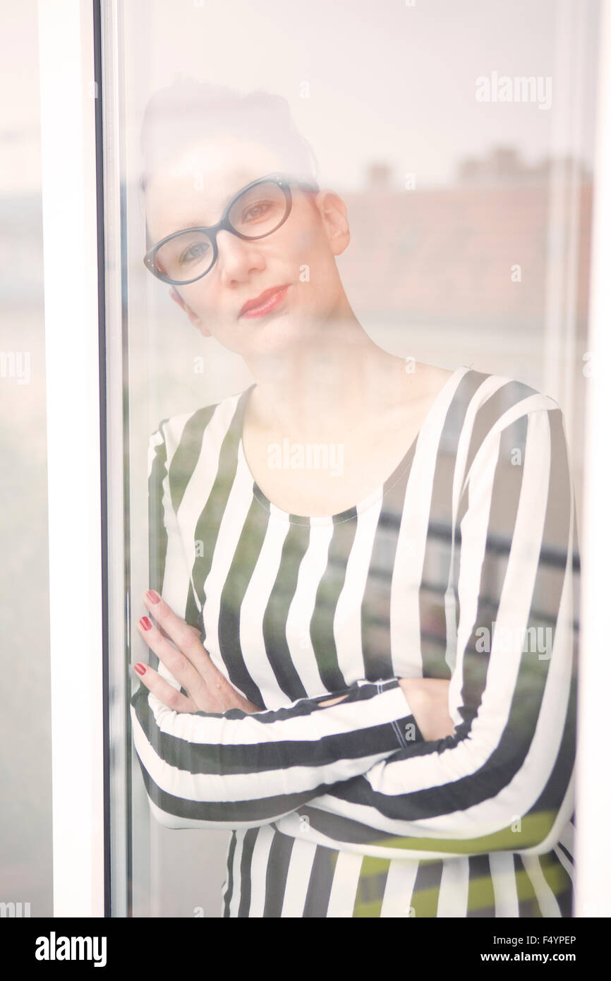 woman with eyeglasses looking through window at camera Stock Photo - Alamy