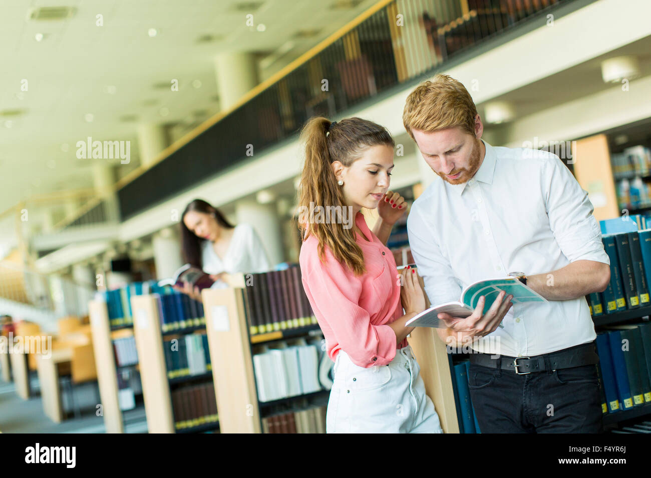 Young couple in the library Stock Photo - Alamy