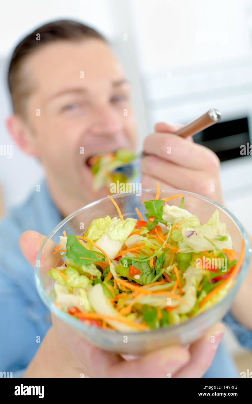 Man eating salad, showing bowl Stock Photo - Alamy