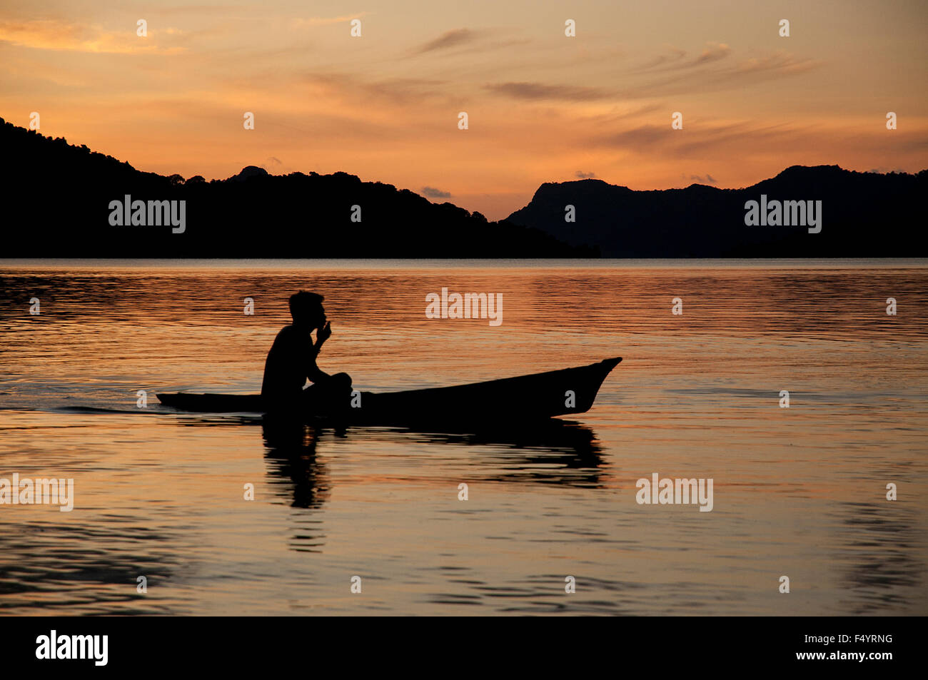 Sea gypsy in the canoe during sunrise at Mabul Maiga Island, Malaysia ...