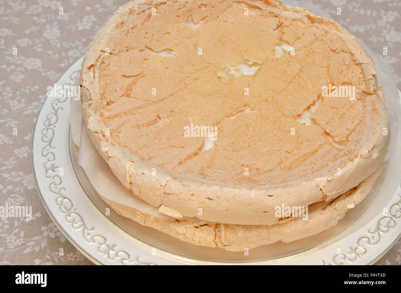 Crispy, fluffy merinque layers for beze cake on white cake plate Stock ...