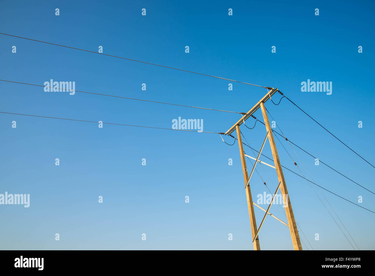 Electricity post and a blue sky background Stock Photo - Alamy