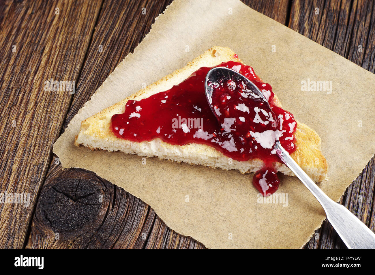 Toasted bread with raspberry jam on dark wooden table Stock Photo - Alamy