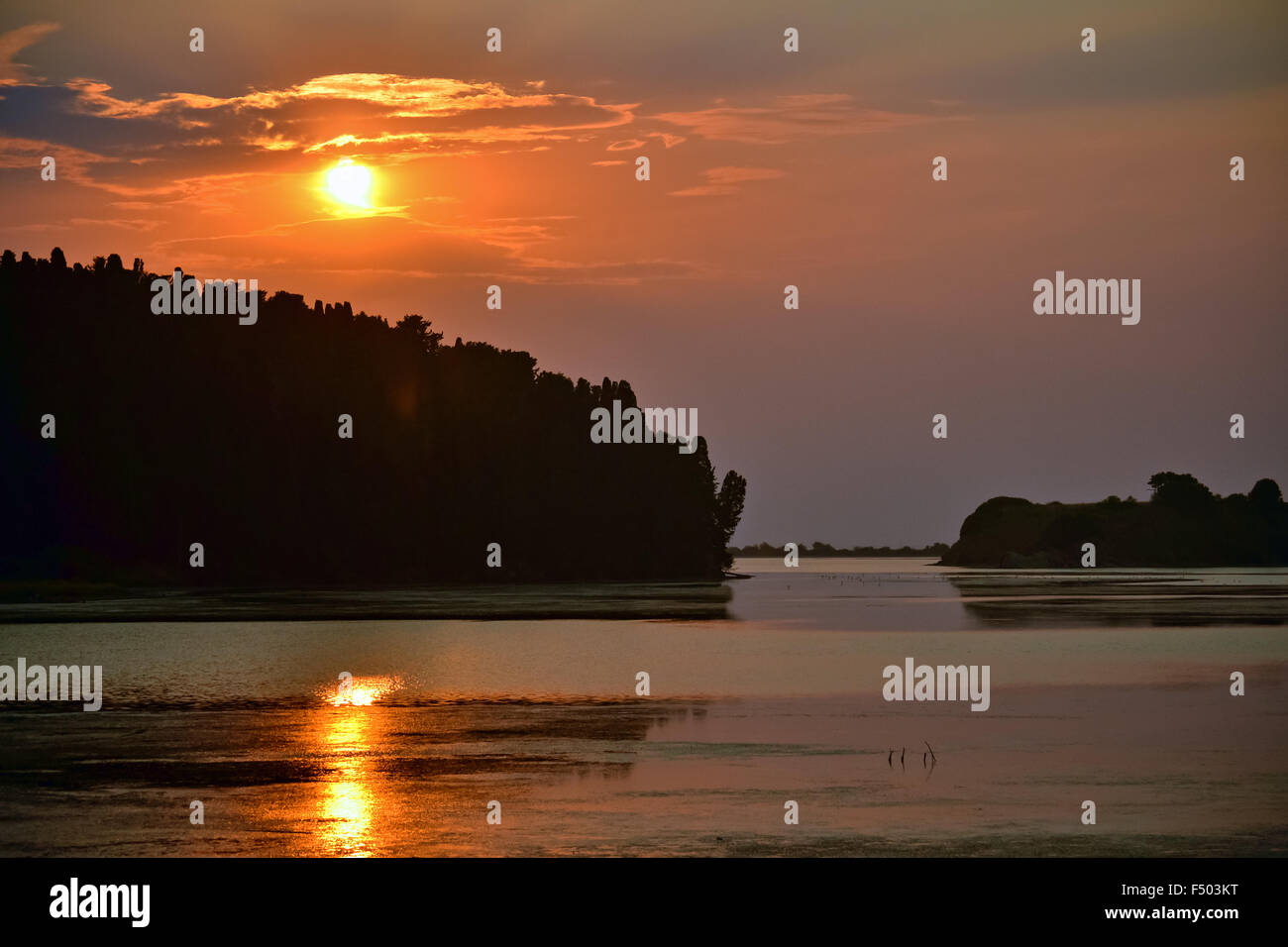 Sunset in summer and sun reflecting in the water in vibrant colors ...