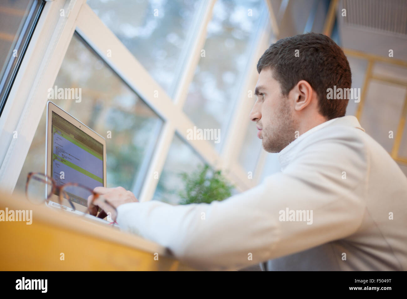Handsome man using computer on workplace Stock Photo - Alamy