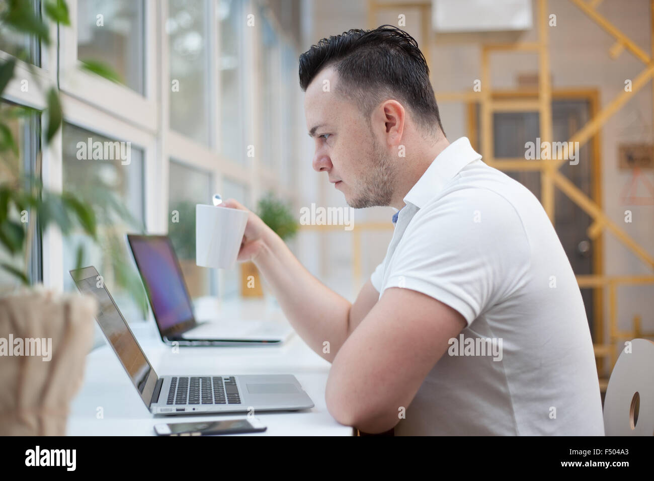 Man using laptop in white office Stock Photo - Alamy