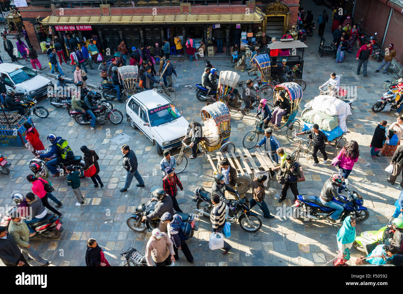 Crowded traffic with pedestrians, rikshaws and cars at a crossroad ...