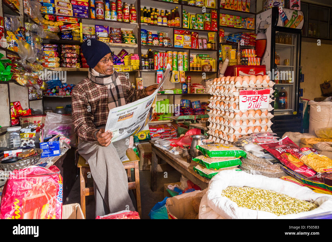 Shopkeeper of a grocery-store reading newspaper Stock Photo - Alamy