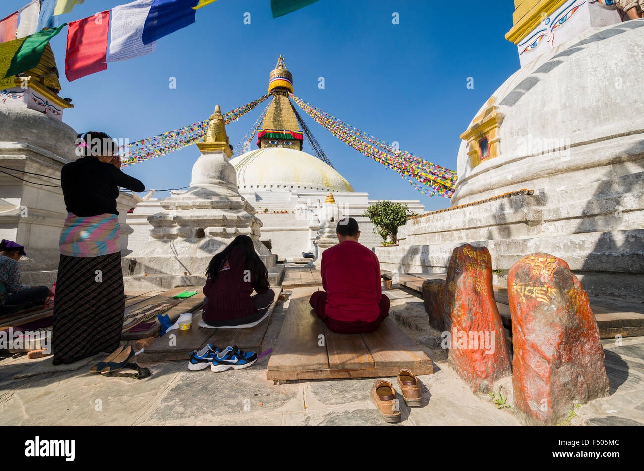 Tibetean pilgrims practicing prostrations at the foot of Boudnath Stupa ...