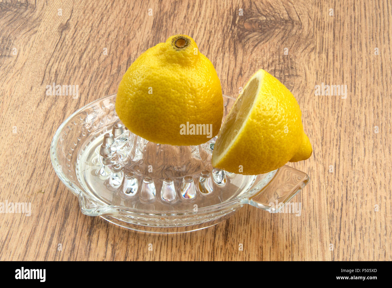 Lemon cut in half being juiced Stock Photo - Alamy