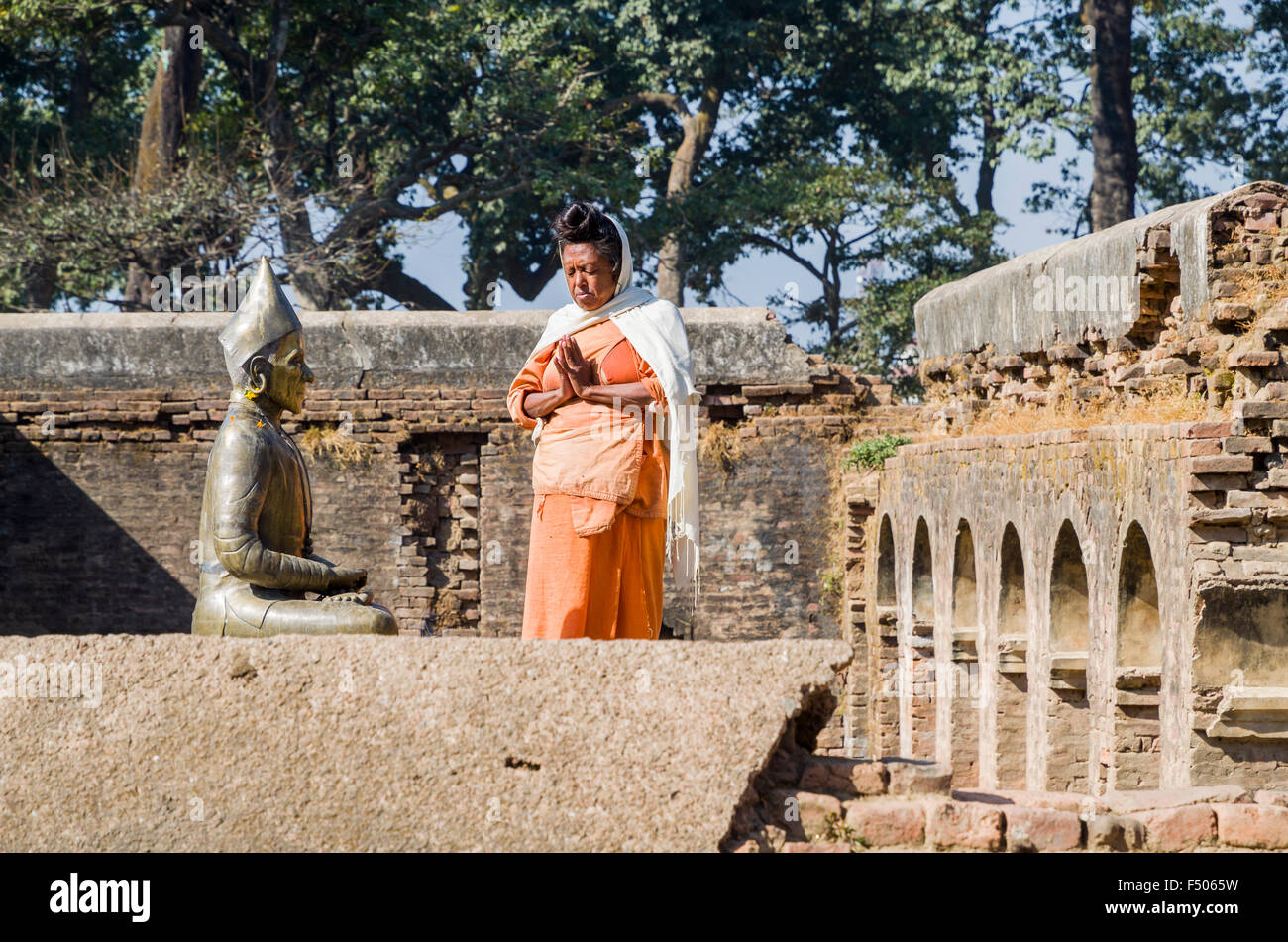 Devotee praying to an image of a saint in the hills above Pashupatinath ...