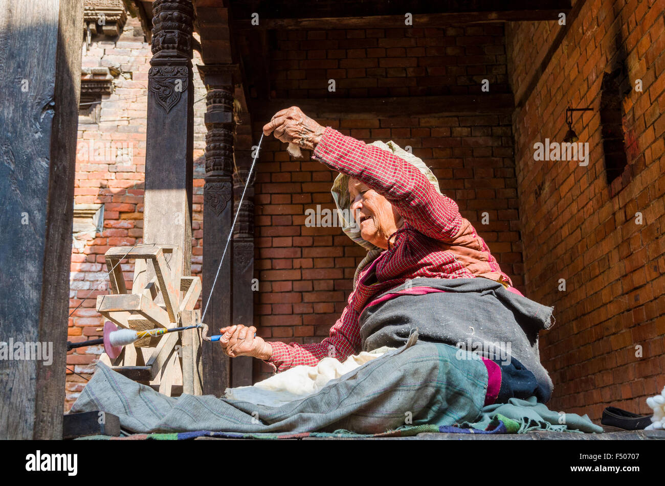Old woman spinning thread Stock Photo - Alamy