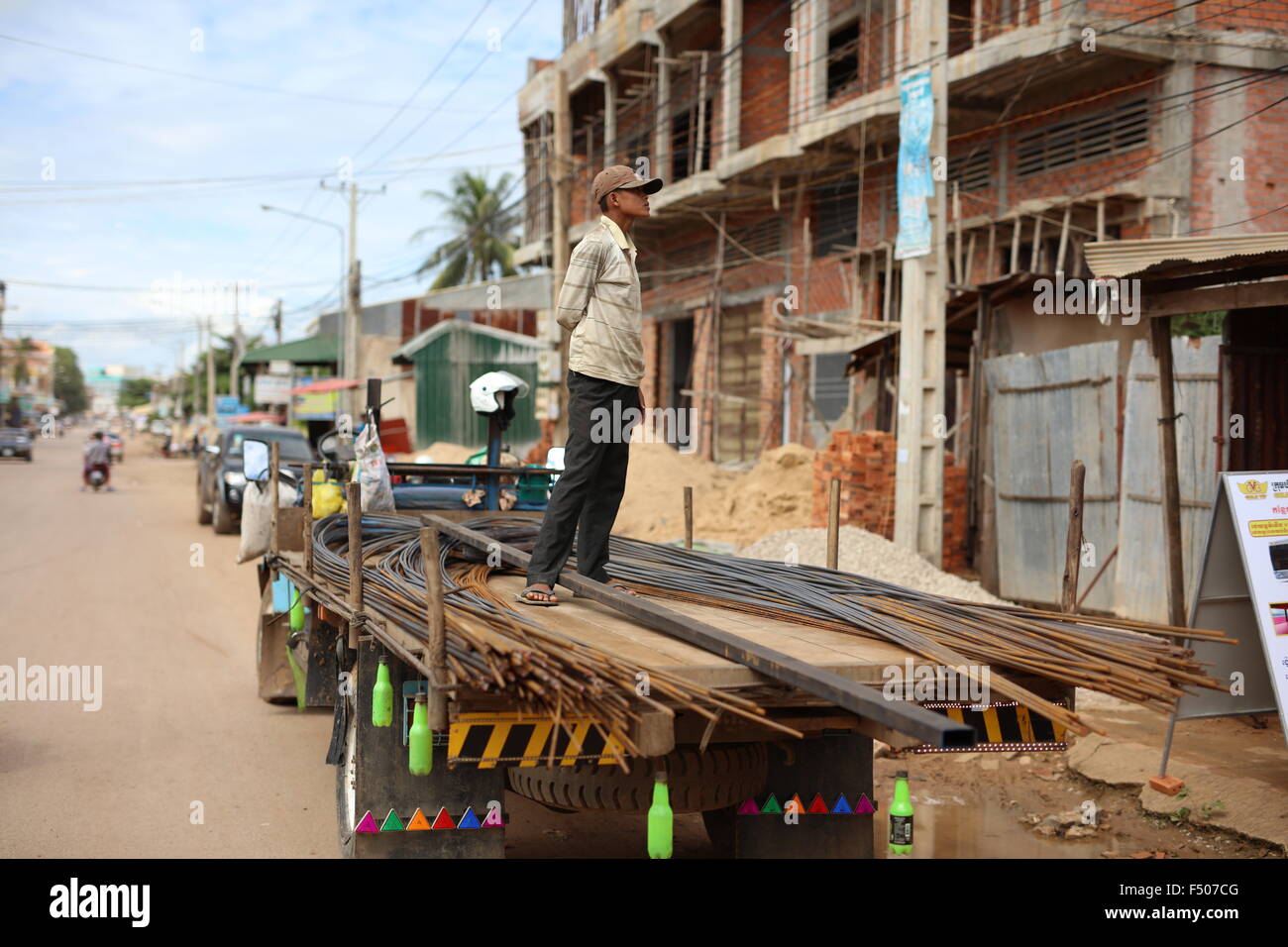 Man delivering reinforcement iron to a building place in Sisophon ...