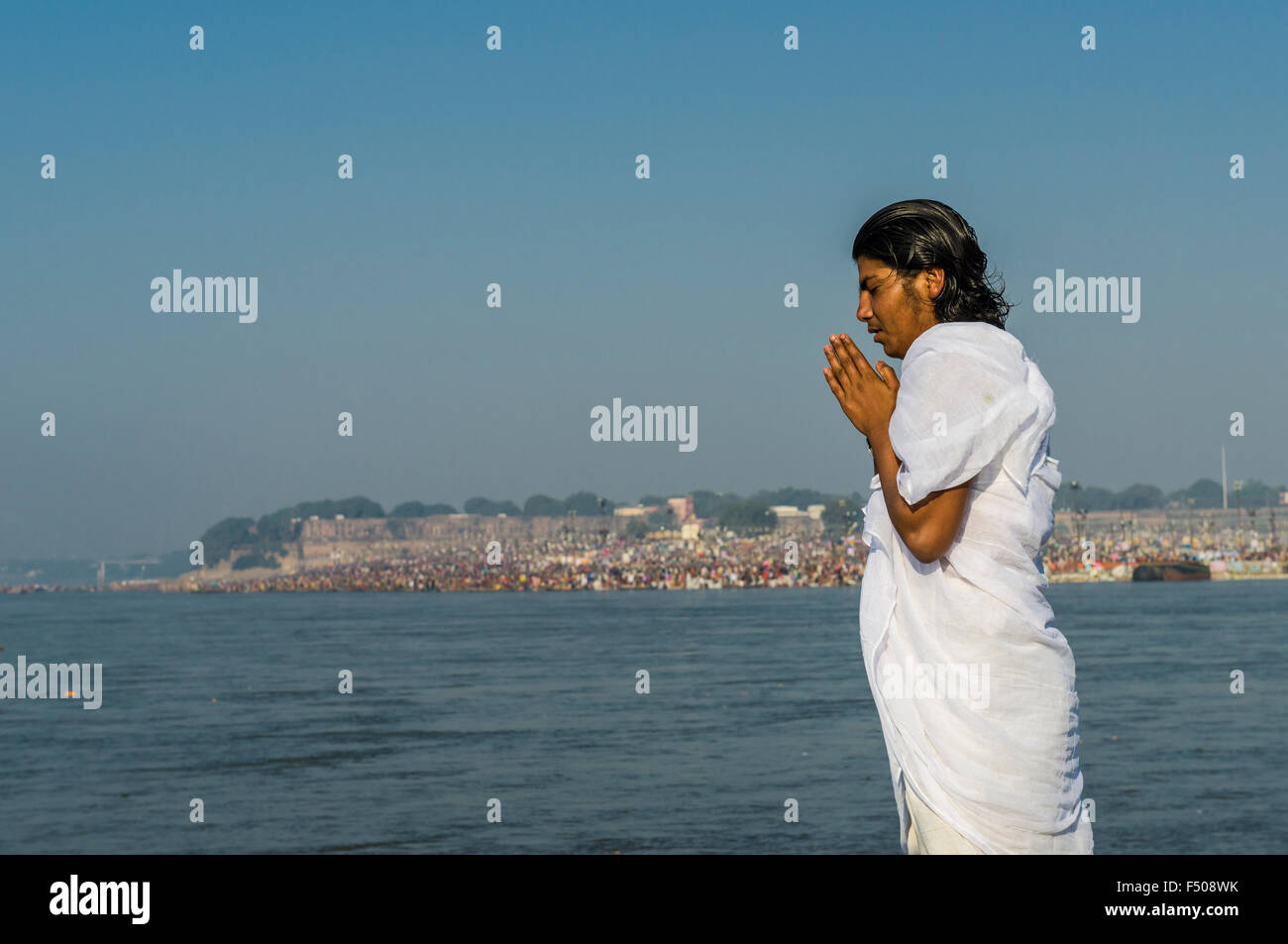 Priest praying at the river Ganges, the crowded Sangam, the confluence ...