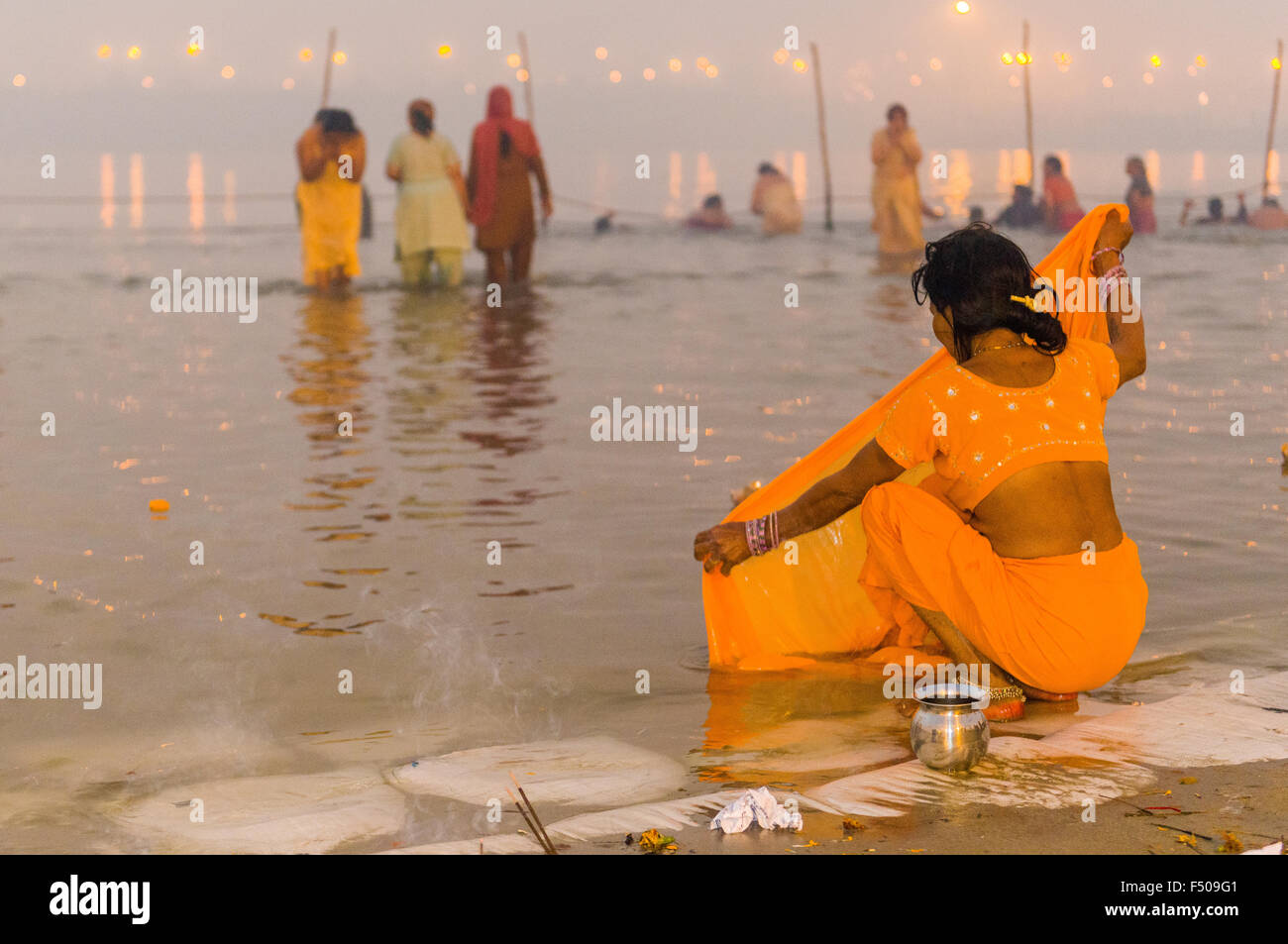 Woman washing her sari after taking bath at the Sangam, the confluence ...