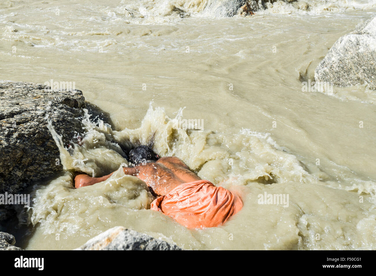 A Sadhu, holy man, is taking bath in the freezing cold water at Gaumukh ...