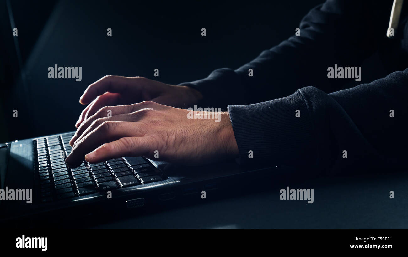 Man hacker typing on laptop keyboard at night Stock Photo - Alamy