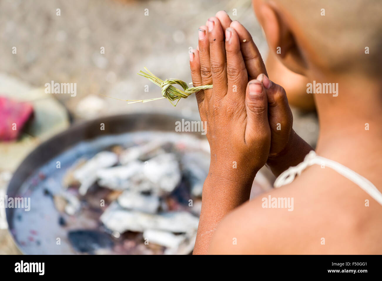 A man is praying during the ritual Dashkriya or Asthi Visarjan, a ...