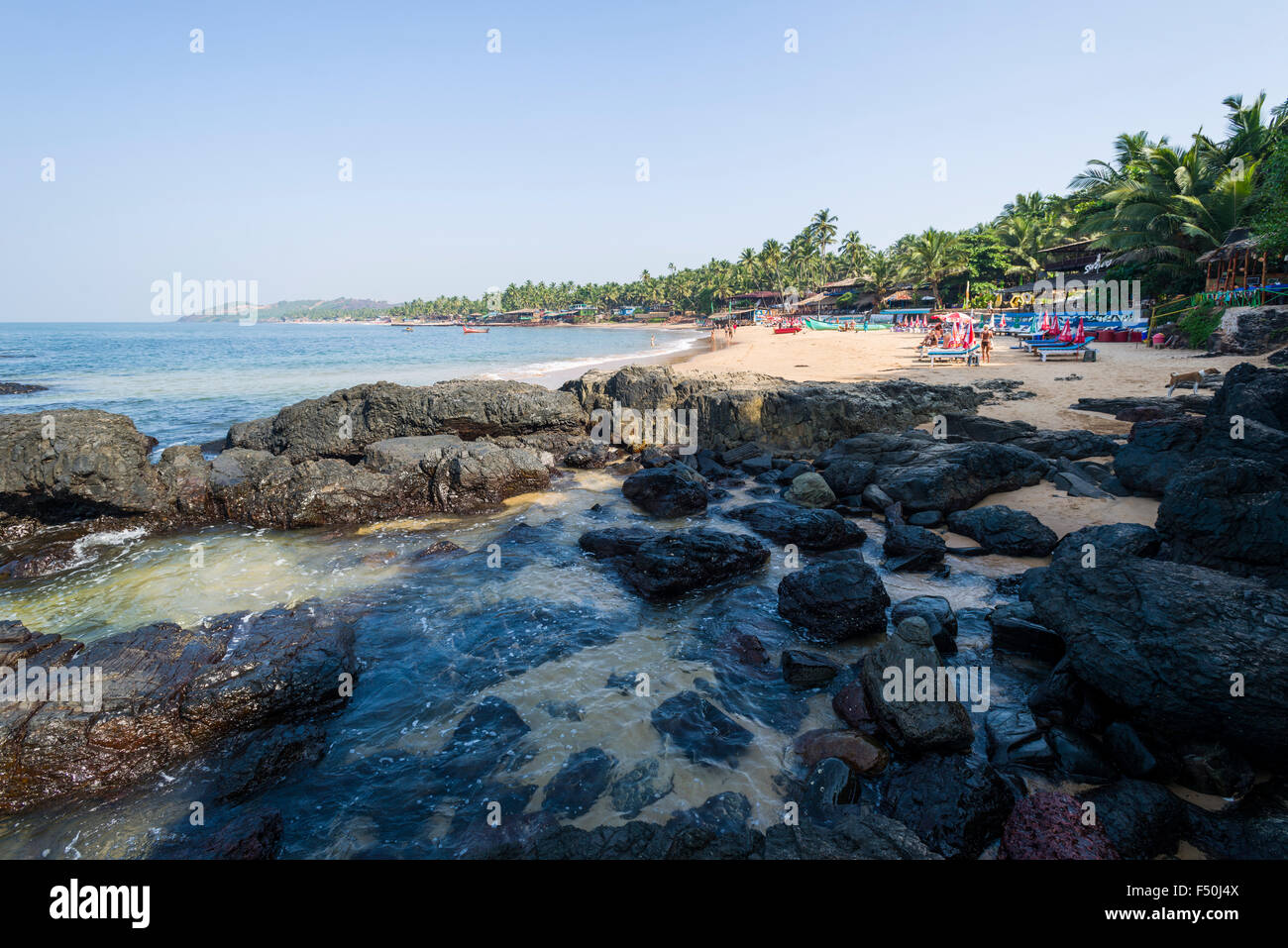The Anjuna Beach with blue sky, white sand and blue sea is one of the ...
