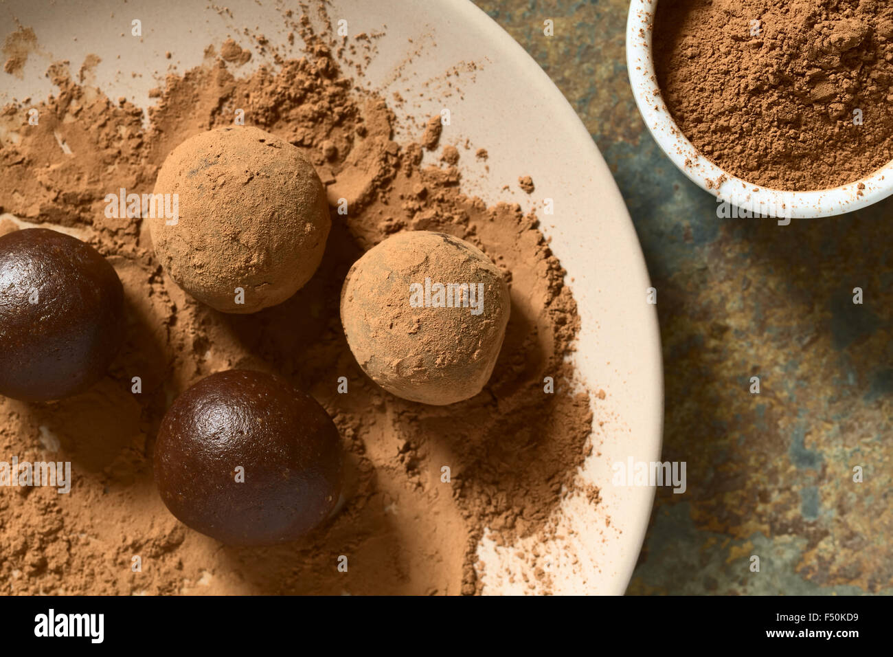 Rum balls being covered with cocoa powder, photographed overhead on ...