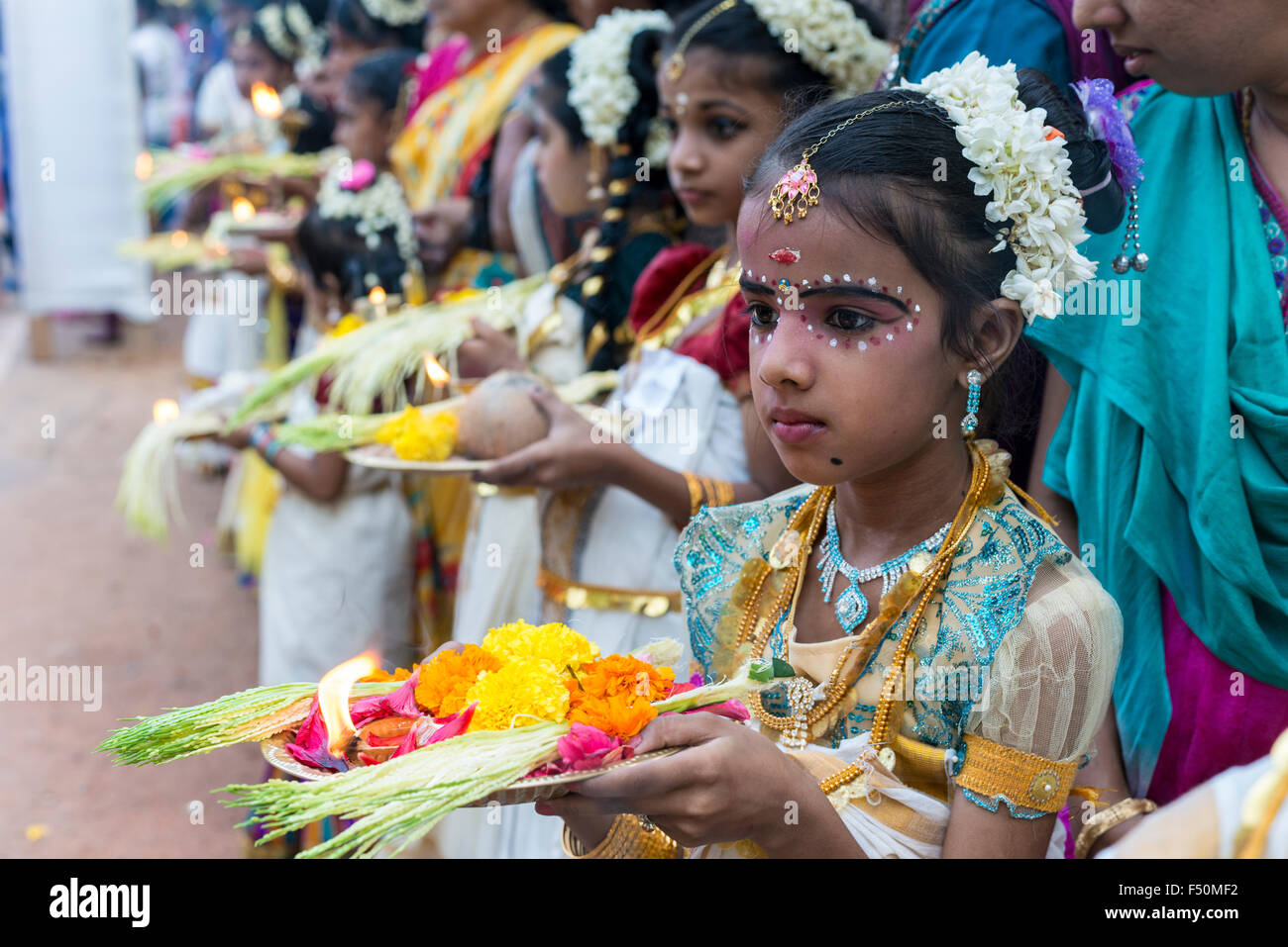 Portrait of a little girl, offering flowers during a temple festival ...