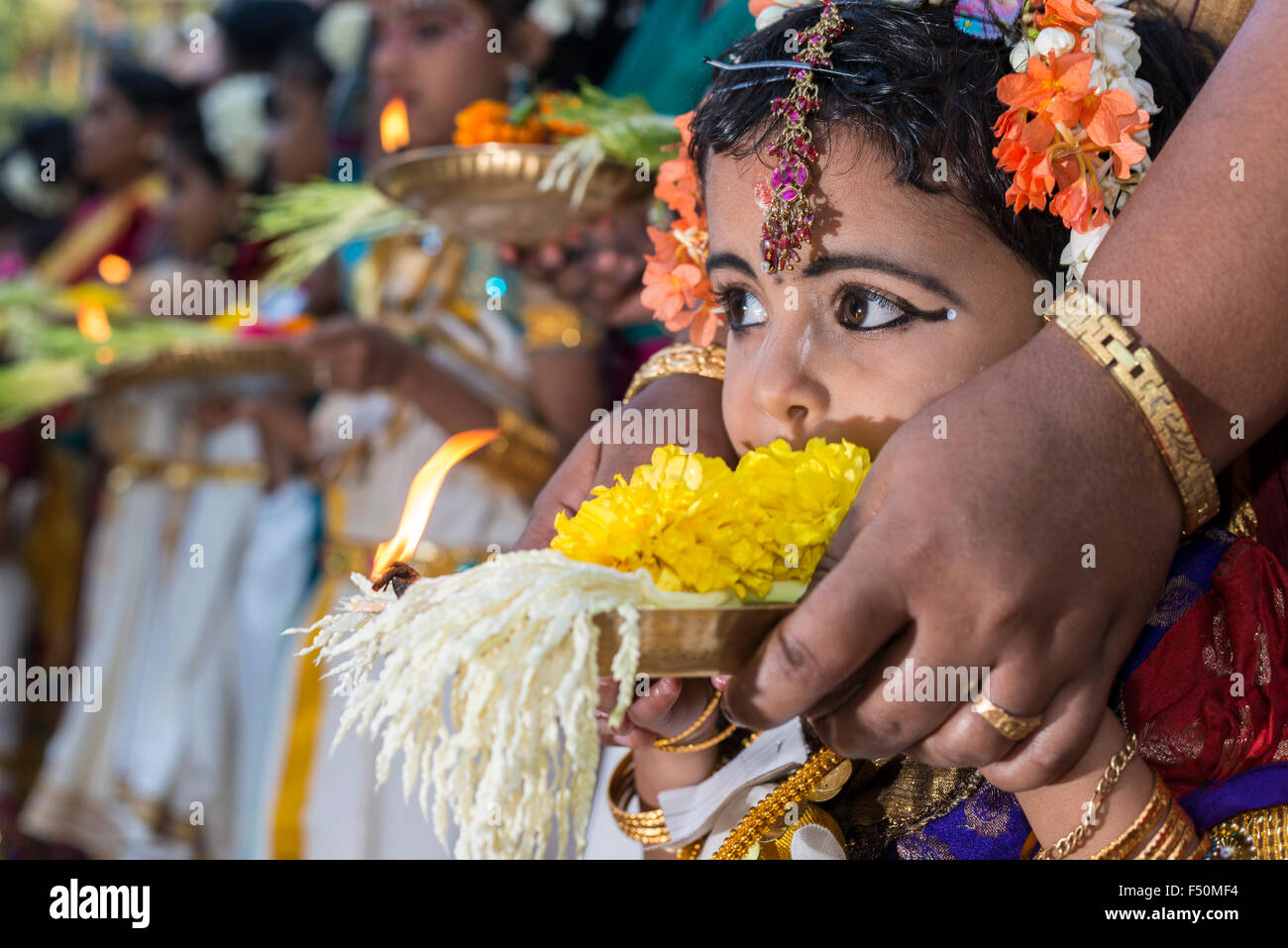 Portrait of a little girl, offering flowers during a temple festival ...