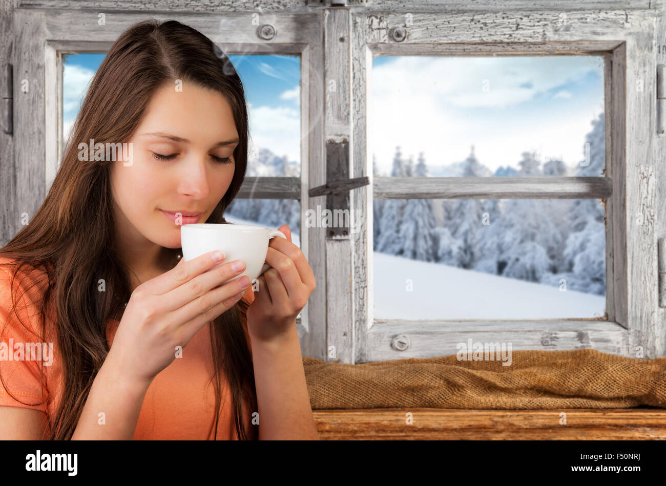 Young woman with cup of tea in front of window Stock Photo - Alamy