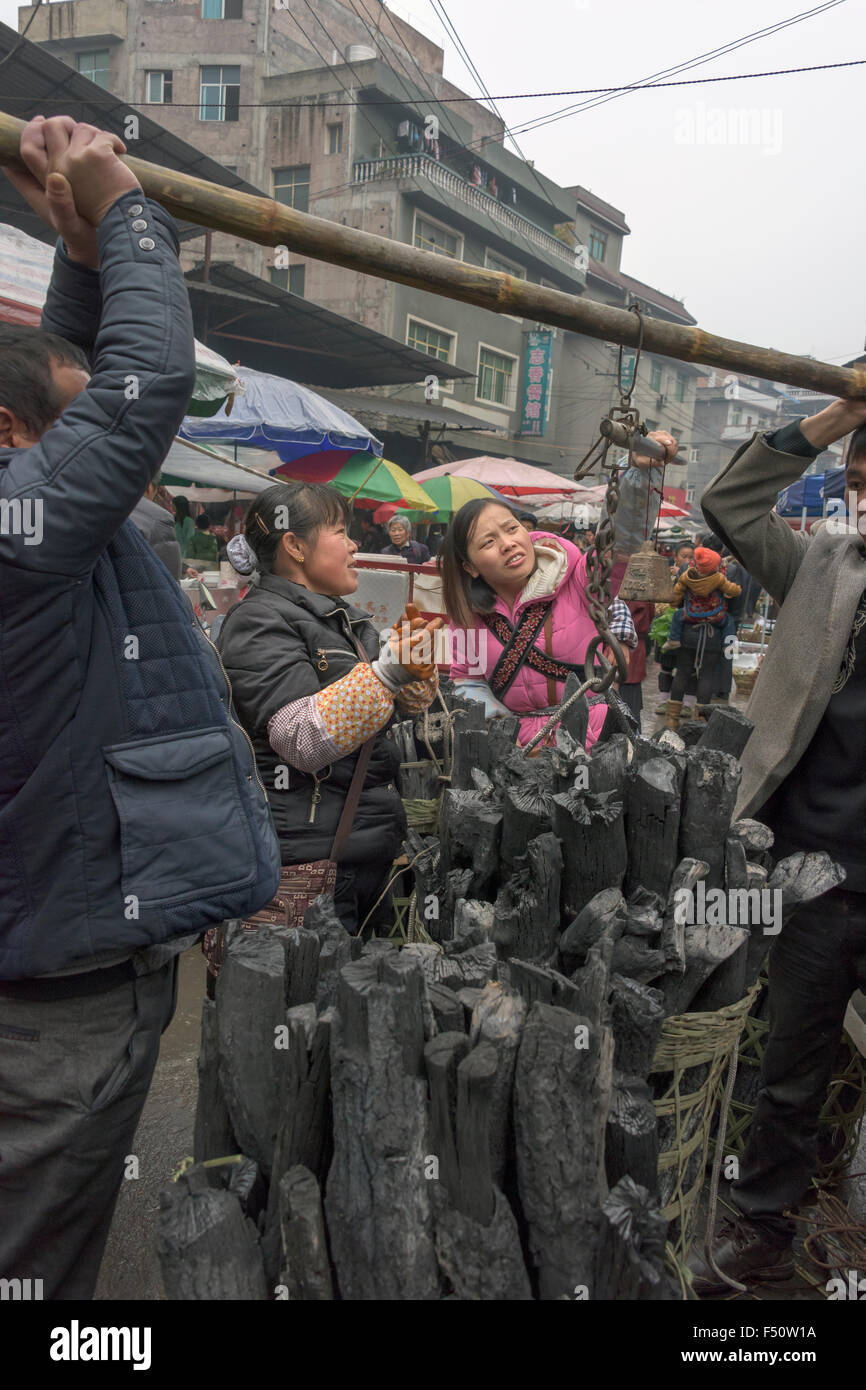 Weighing a basket of charcoal with a traditional Chinese scale ...
