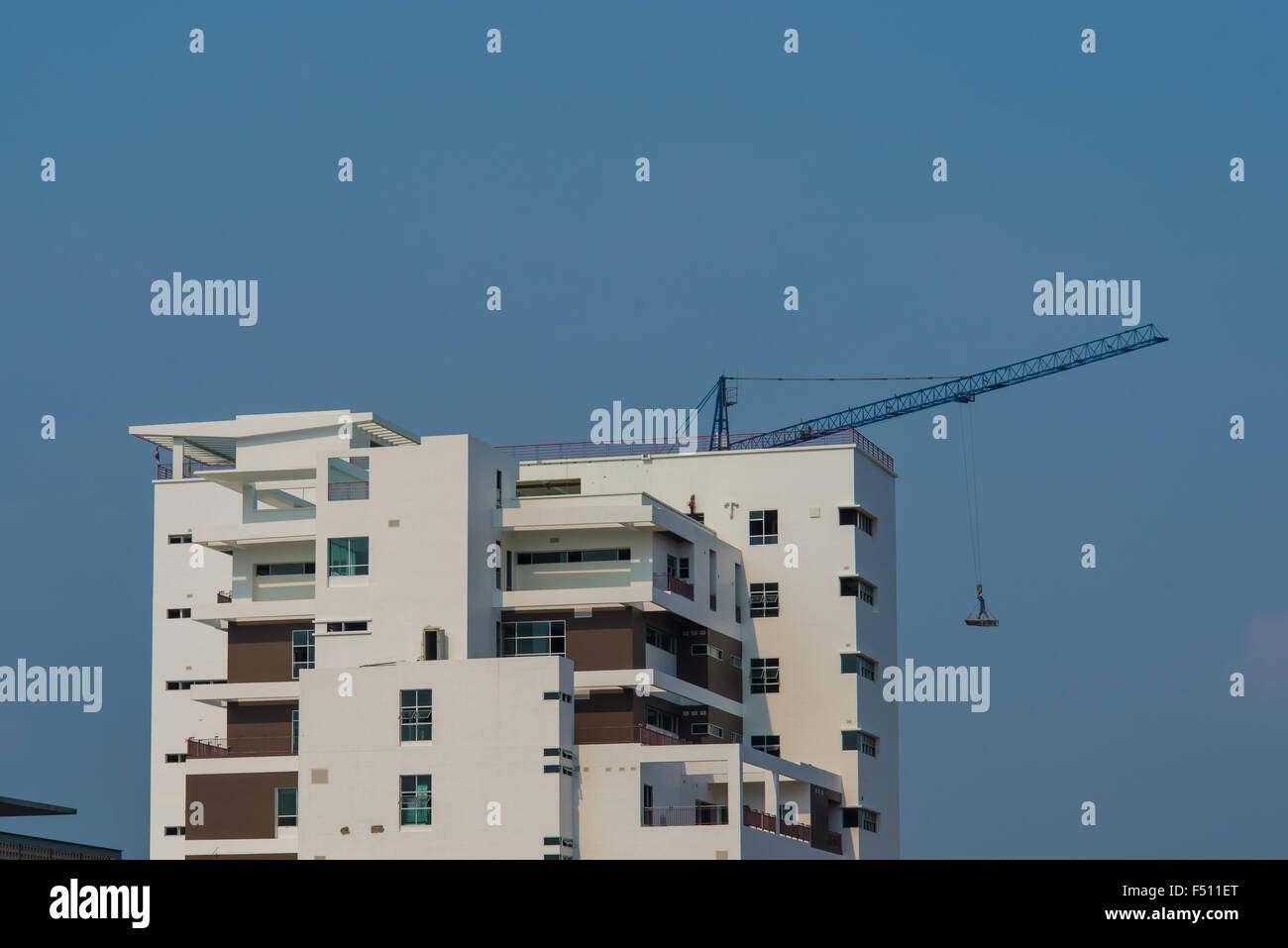 man standing on iron bars held up by mega crane Stock Photo - Alamy